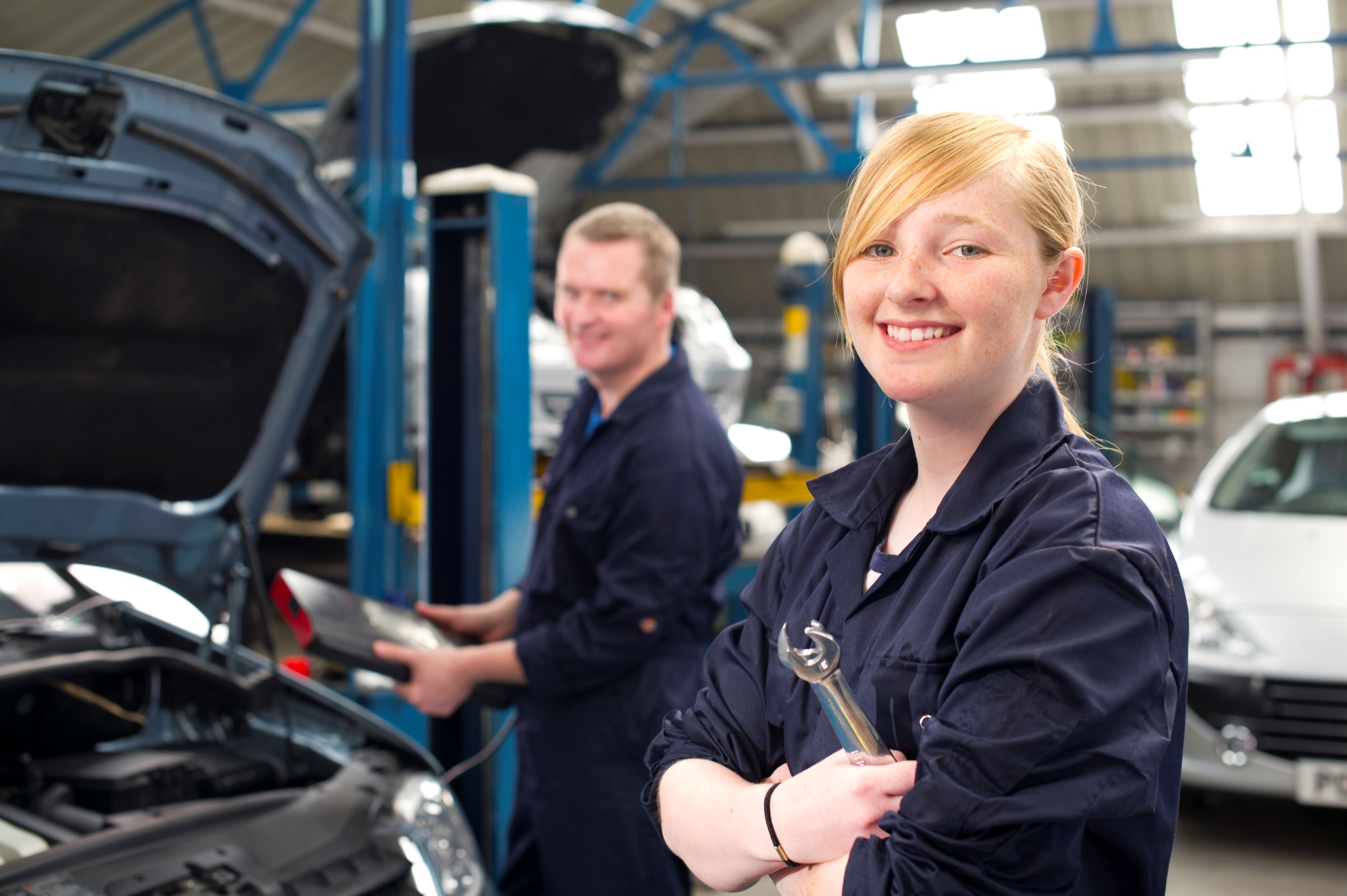 Mechanic apprentice in front of car she is working on