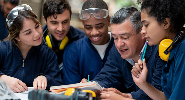 Apprentices standing around the teacher learning